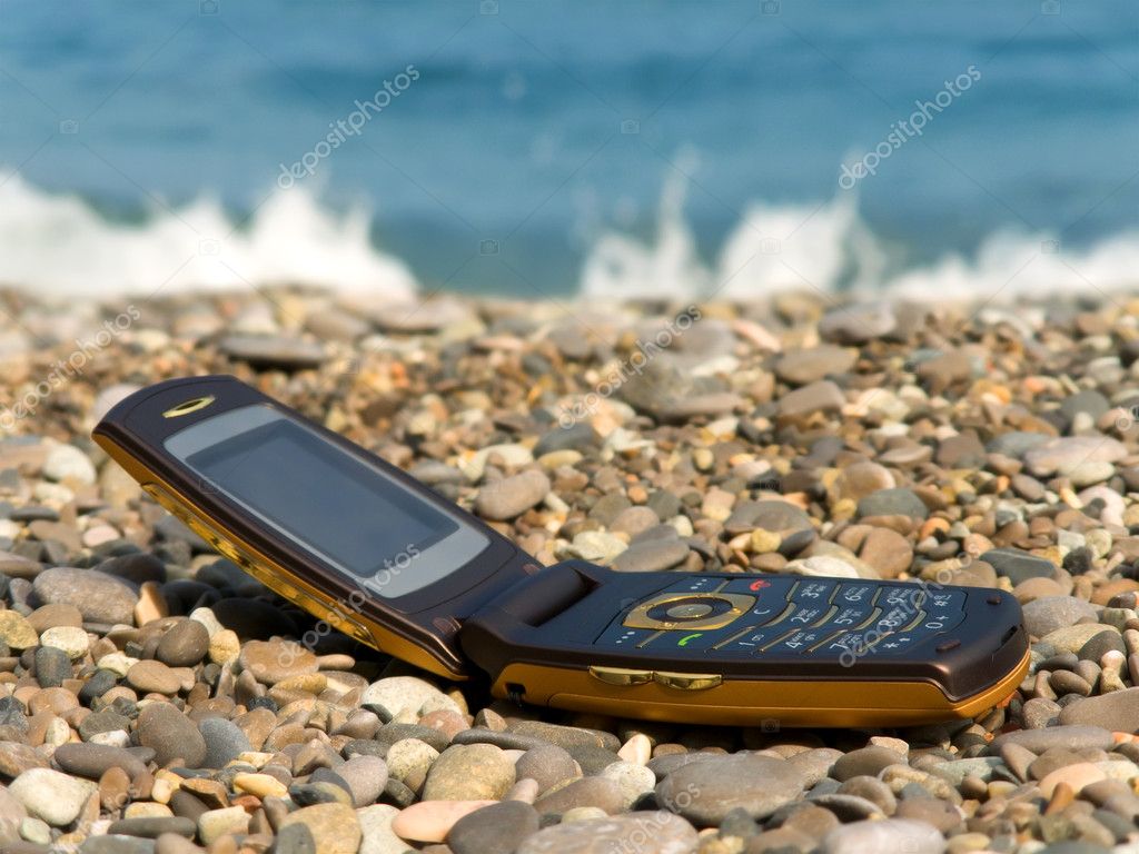 Open mobile phone on beach Stock Photo by ©Violin 3966041