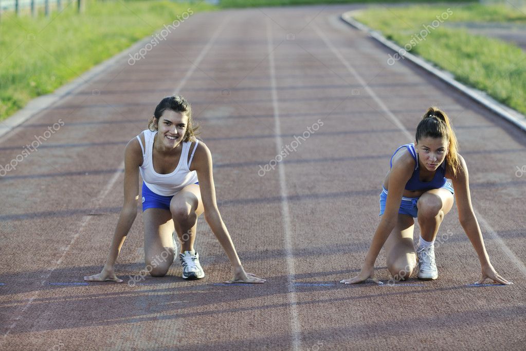 Two girls running on athletic race track Stock Photo by ©.shock 3343742