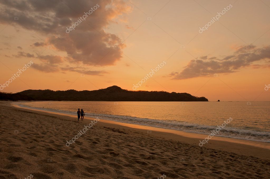 Couple walking on the beach at sunset. — Stock Photo © dmvphotos #2913980