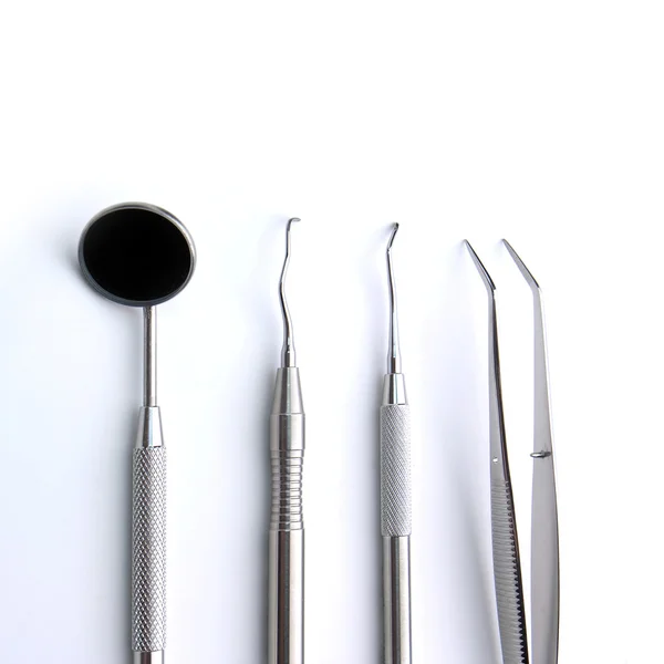 Five dentist instruments for dental treatment on white background ...